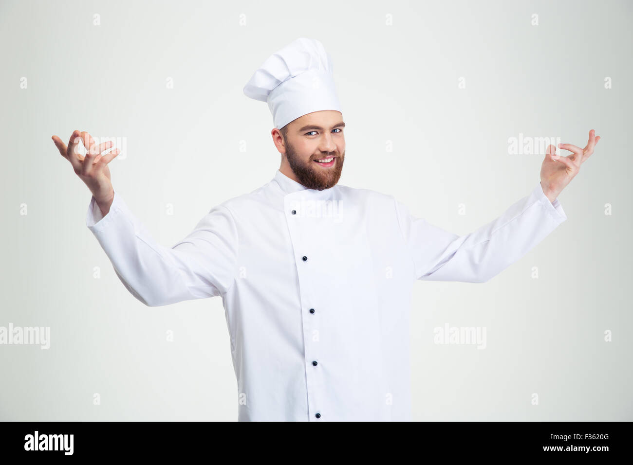 Portrait of a happy chef cook showing welcome gesture isolated on a ...