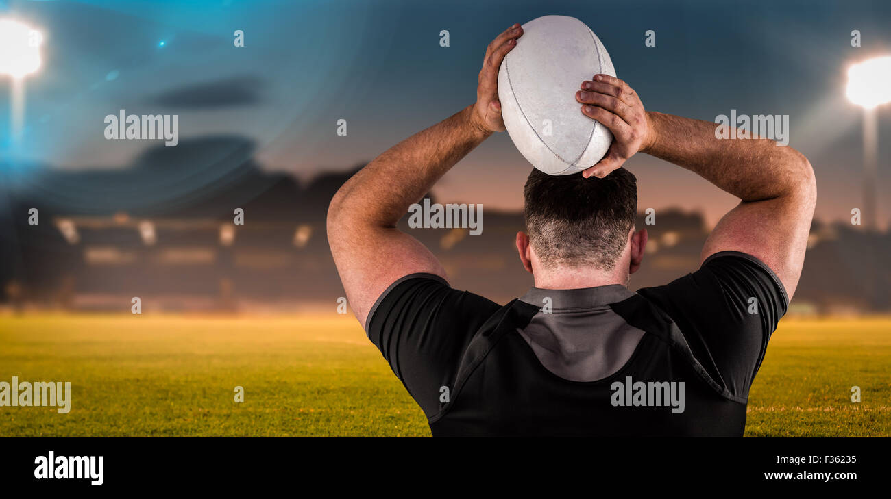 Composite image of tough rugby player throwing ball Stock Photo - Alamy