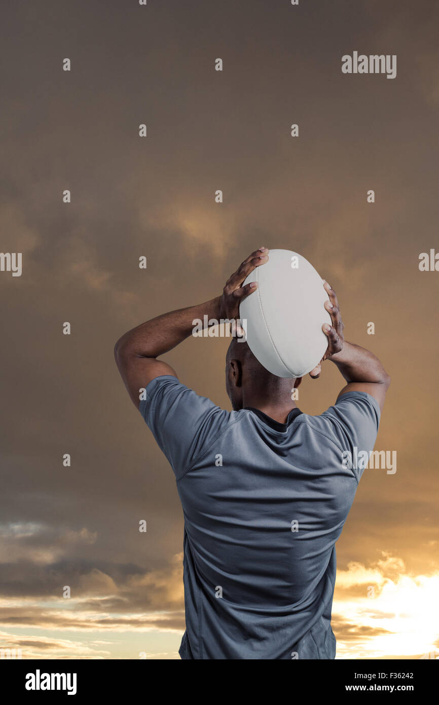 Composite image of rear view of sportsman throwing rugby ball Stock ...