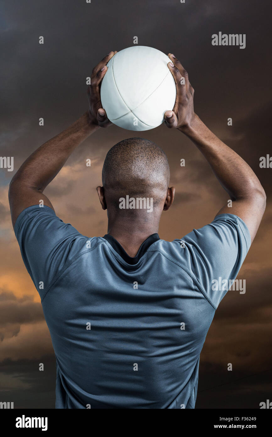 Composite image of rear view of athlete throwing rugby ball Stock Photo ...