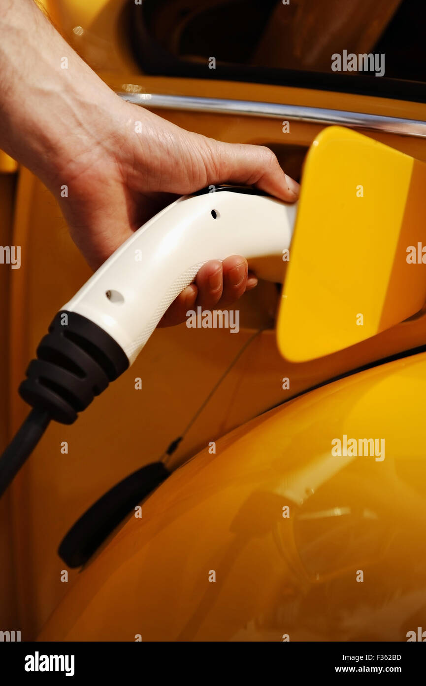 Detail shot with an electric plug in connected and charging a classic ...