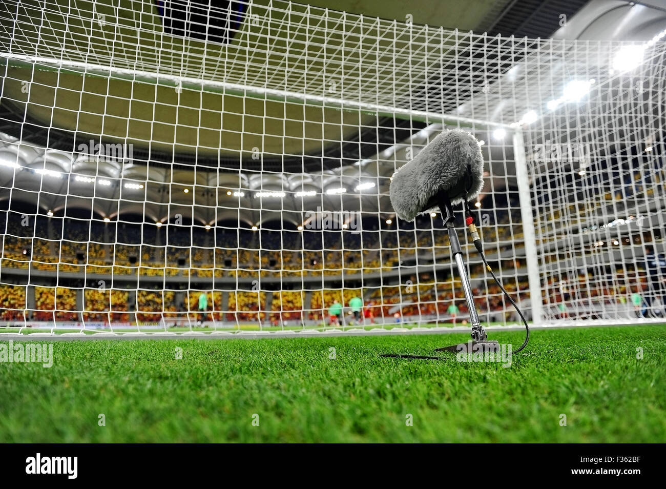 Big and furry sport microphone on a soccer field behind the goal net ...