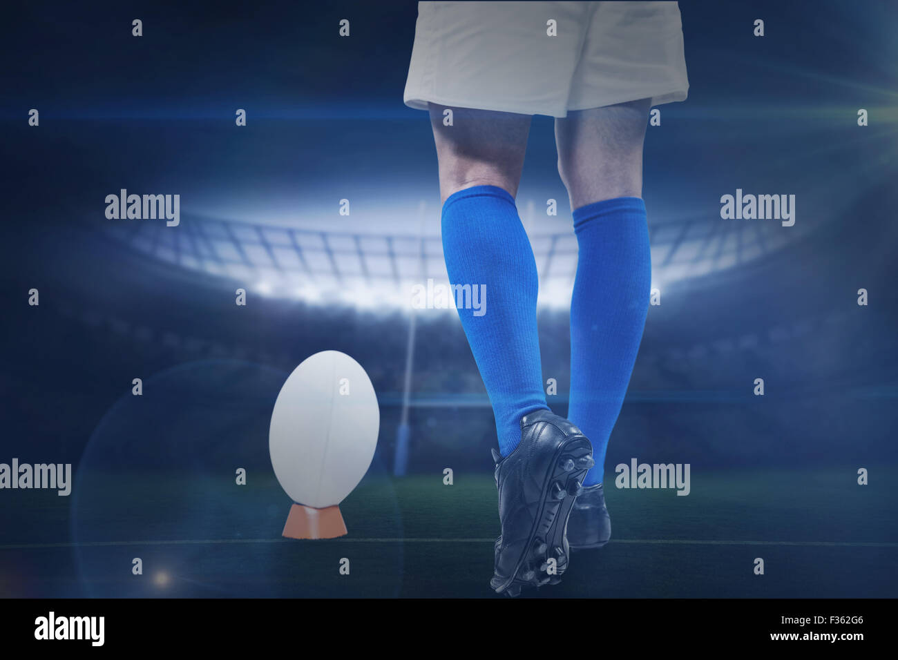 Composite image of low section of rugby player going to kick the ball ...