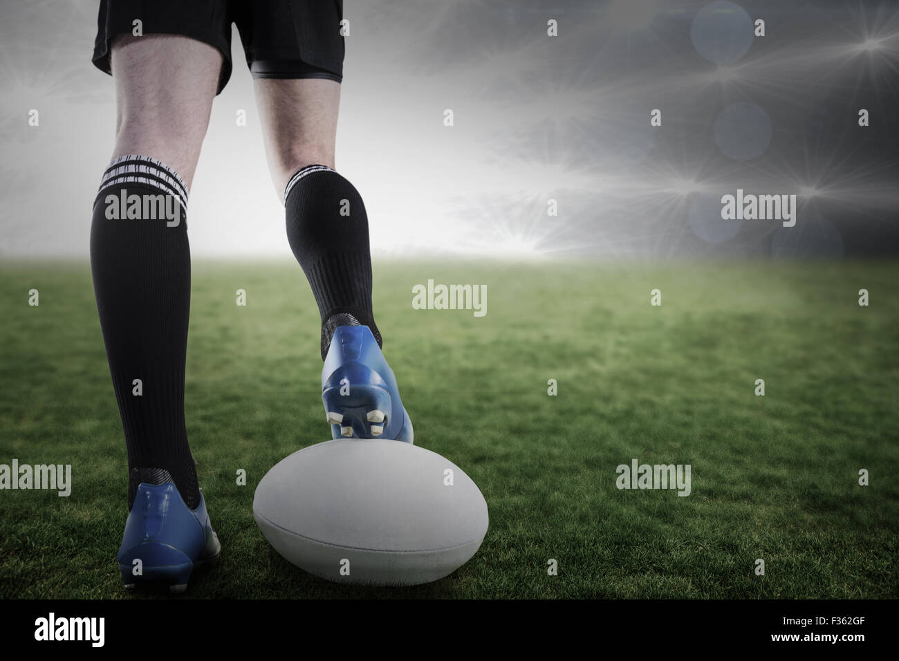 Composite image of rugby player posing feet on the ball Stock Photo - Alamy