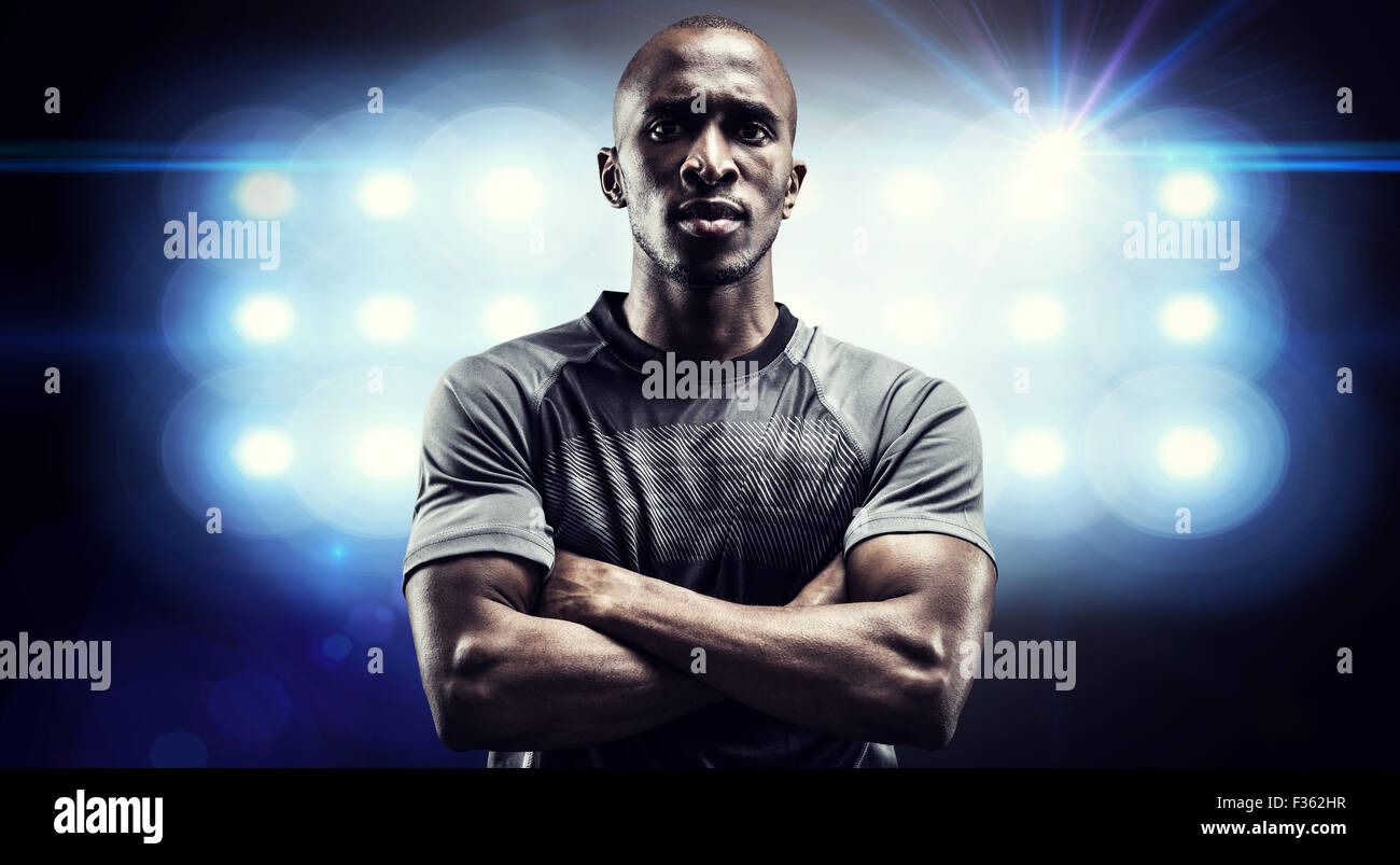 Composite image of portrait of confident rugby player with arms crossed ...