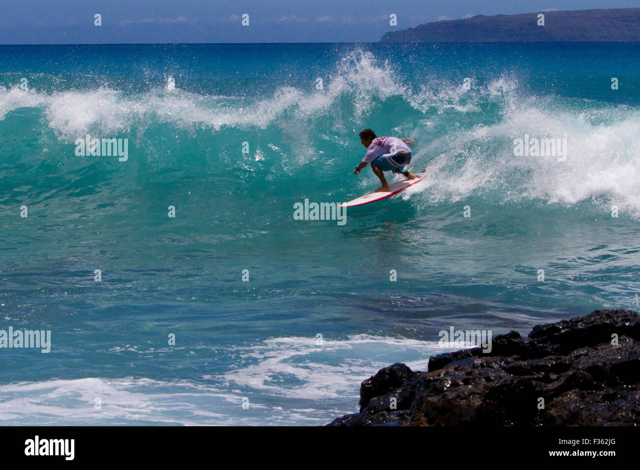 A surfer riding the waves at Kanahena Beach, Maui, Hawaii in July Stock ...