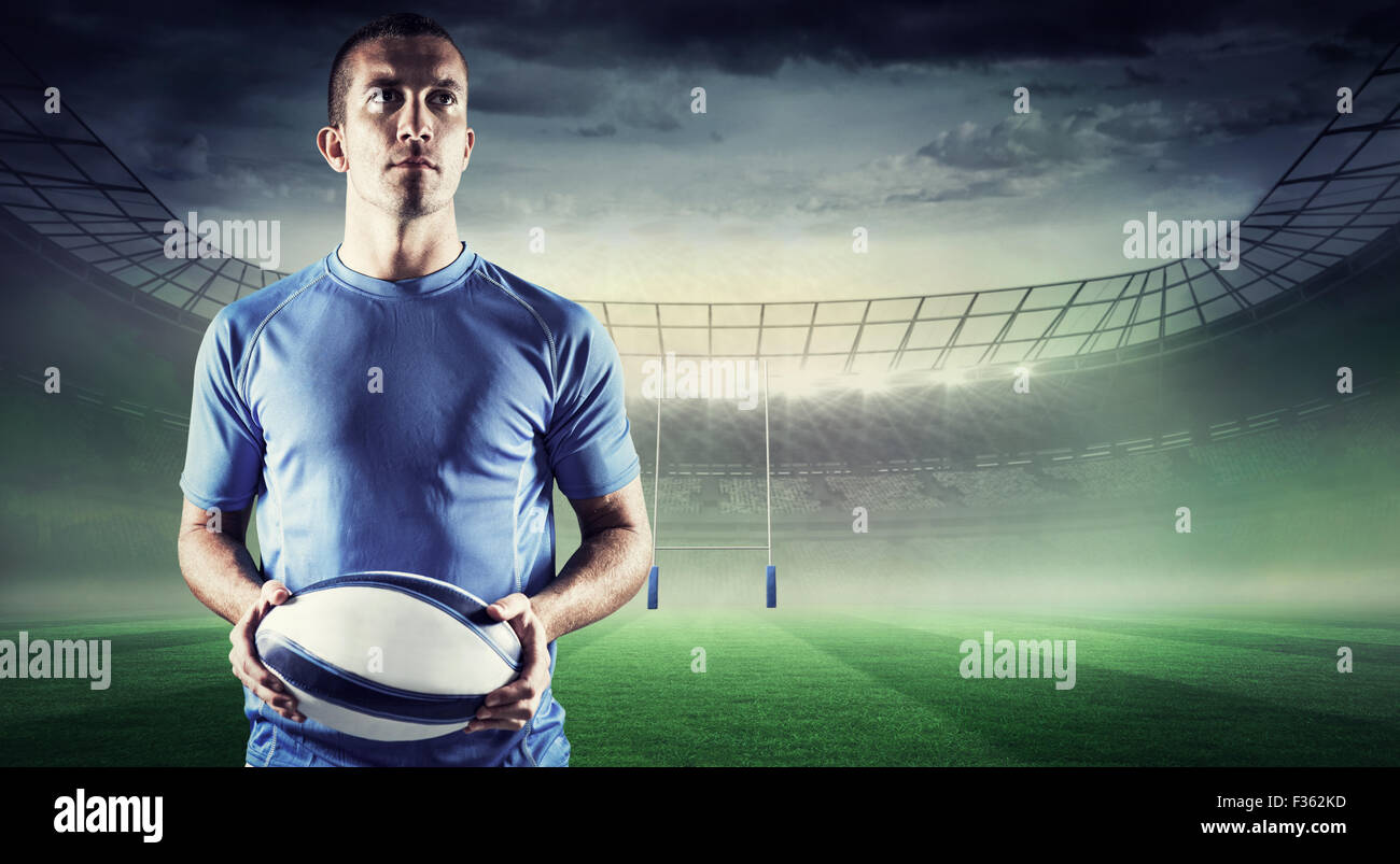Composite image of confident rugby player holding ball Stock Photo - Alamy
