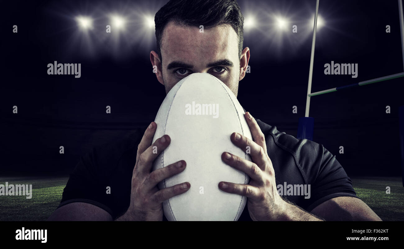 Composite image of tough rugby player holding ball Stock Photo - Alamy