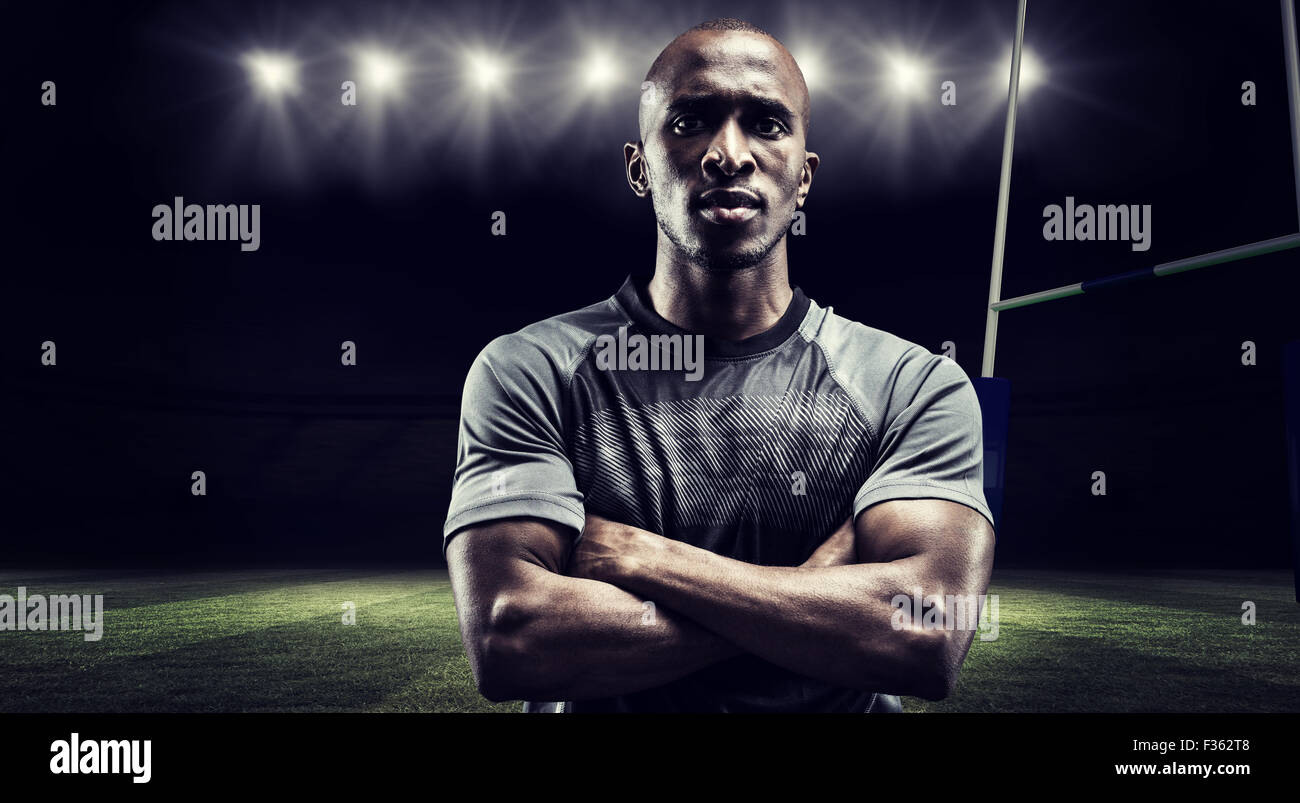 Composite image of portrait of confident rugby player with arms crossed ...