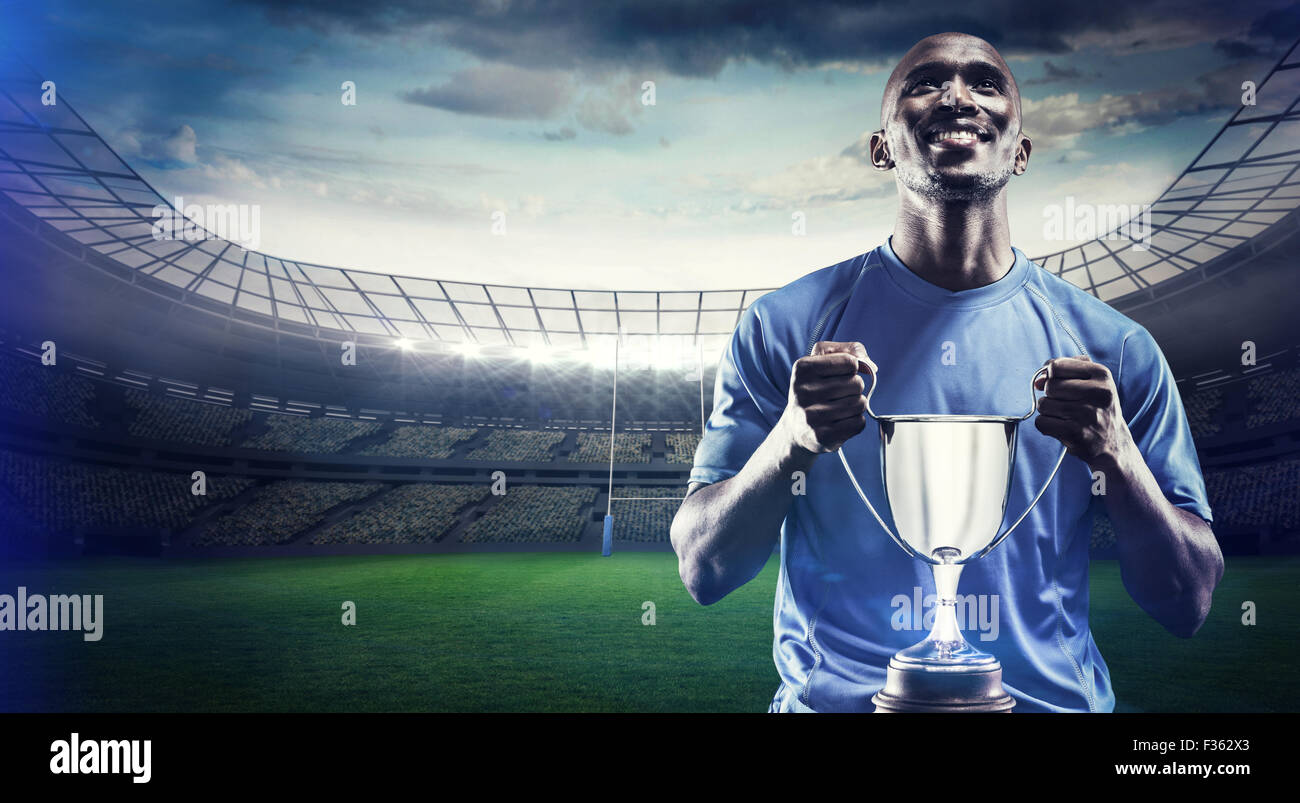 Composite image of happy athlete holding trophy looking up Stock Photo ...