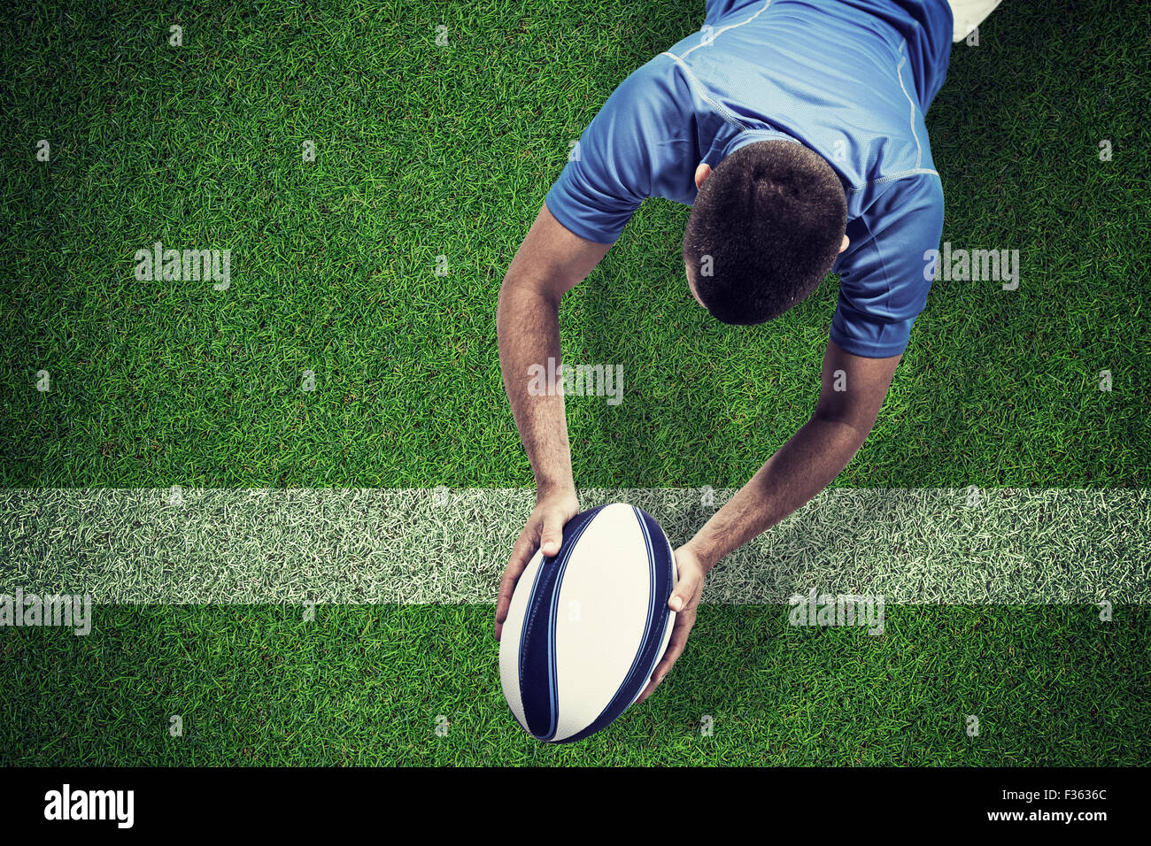 Composite image of rugby player lying in front with ball Stock Photo ...