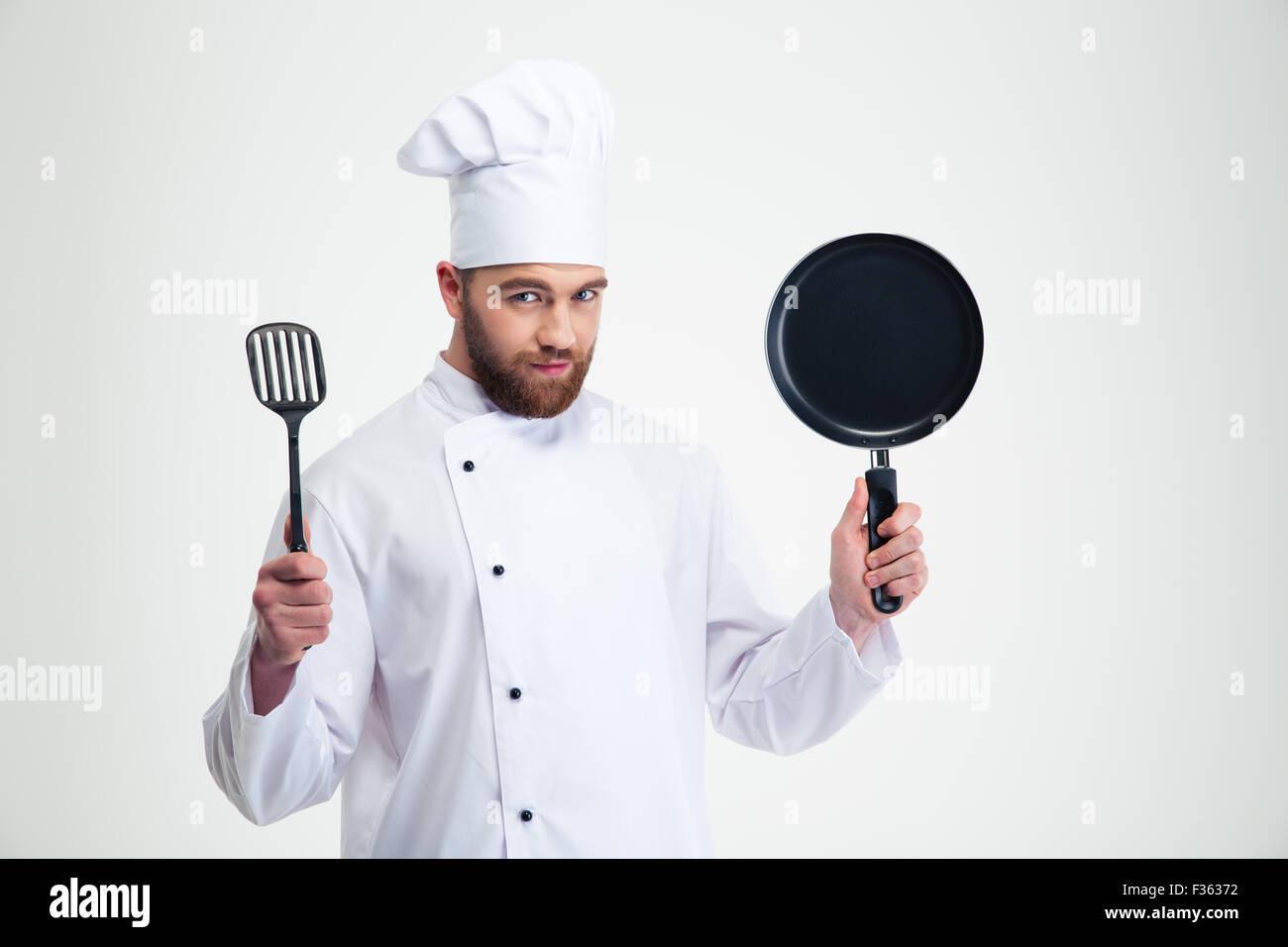 Portrait of a handsome male chef cook holding pan and spoon isolated on ...