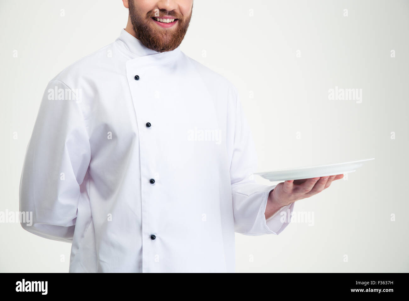Cropped image of a happy male chef cook holding empty plate isolated on ...
