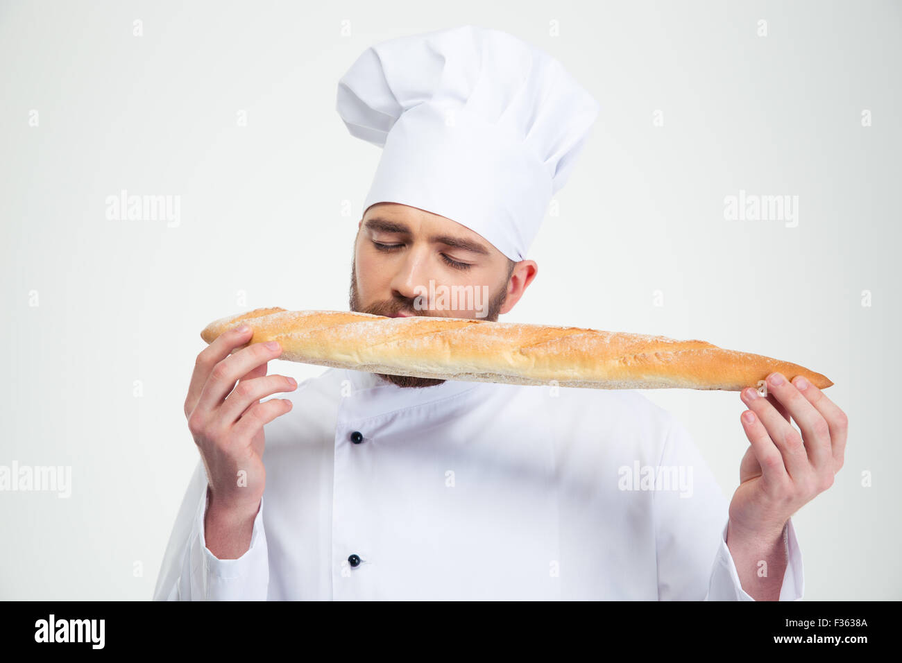 Portrait of a male chef cook smelling fresh bread against white ...