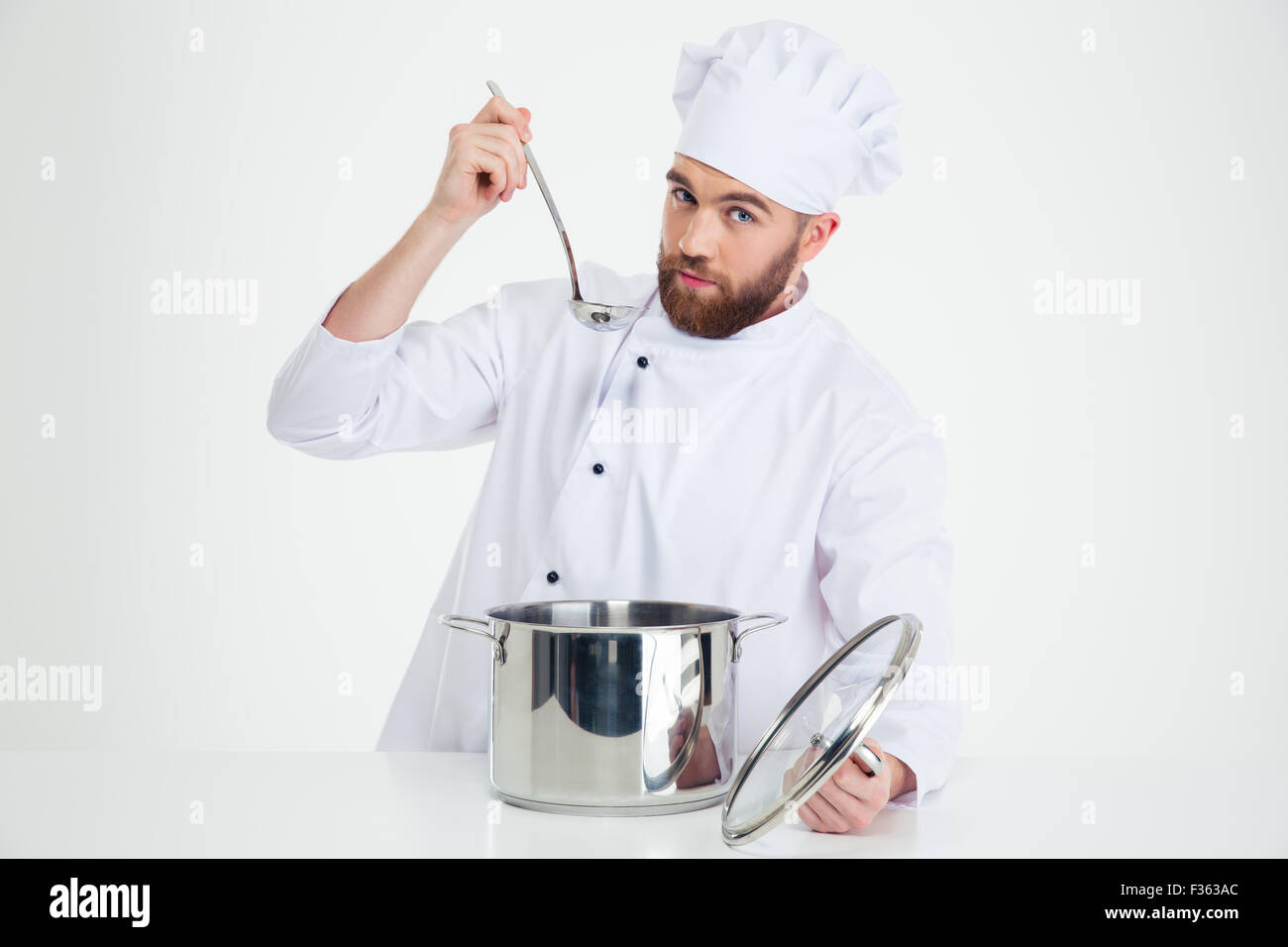 Portrait of a handsome male chef cook tasting food isolated on a white ...