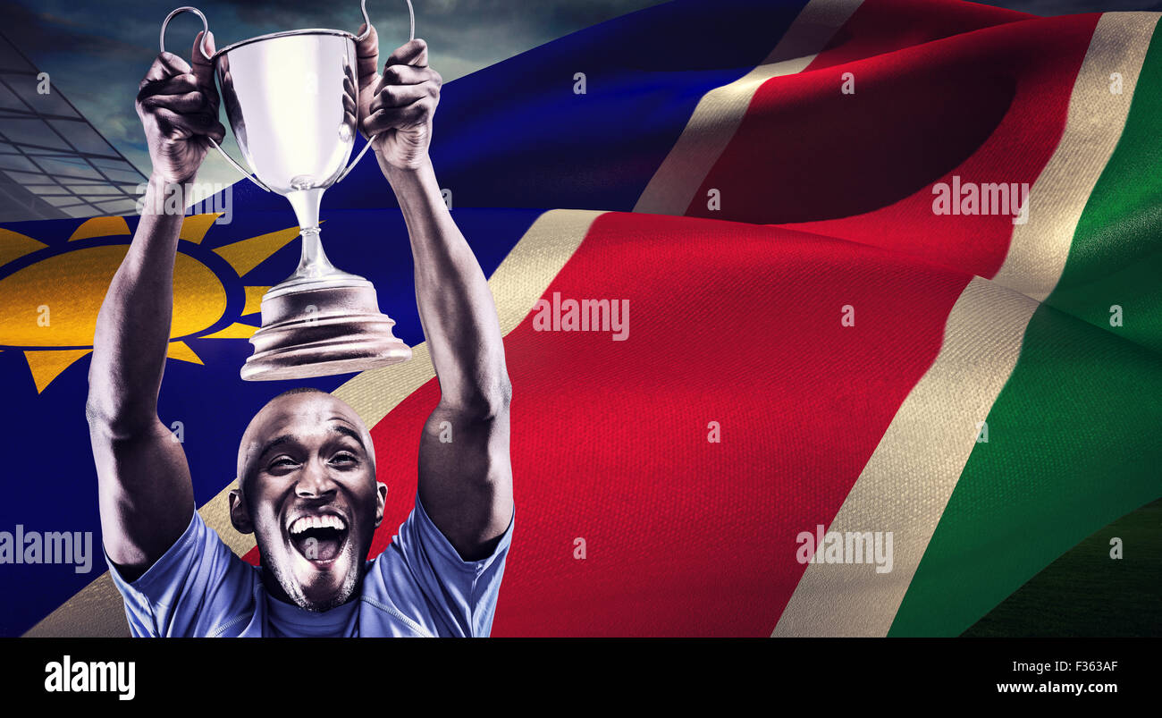 Composite image of happy athlete cheering while holding trophy Stock ...