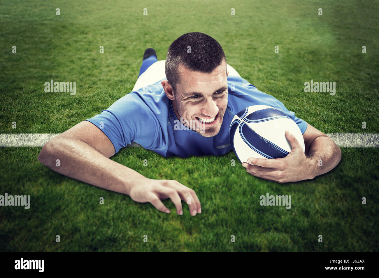 Composite image of confident rugby player lying in front with ball ...