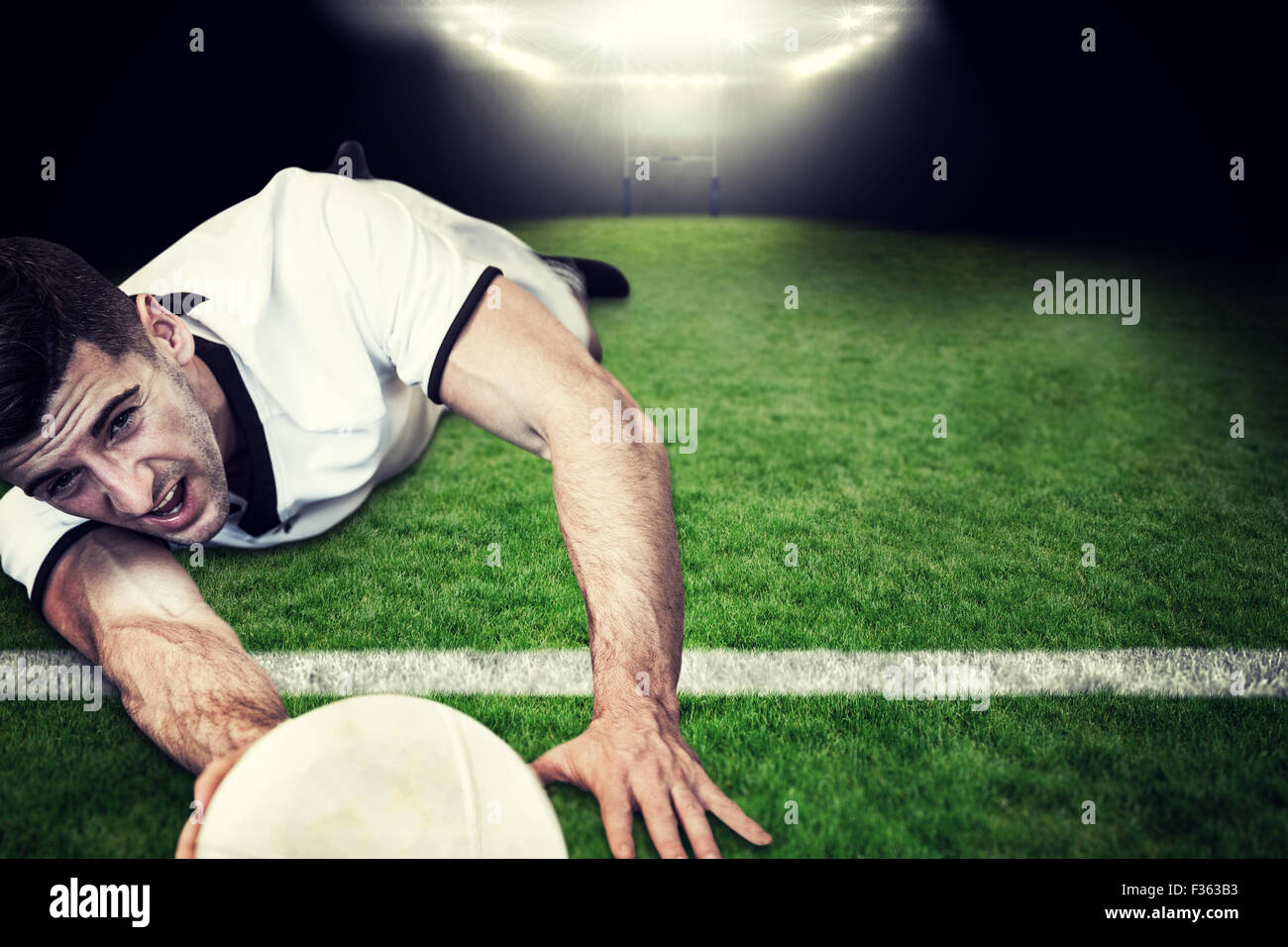 Composite image of man holding rugby ball while lying down Stock Photo ...