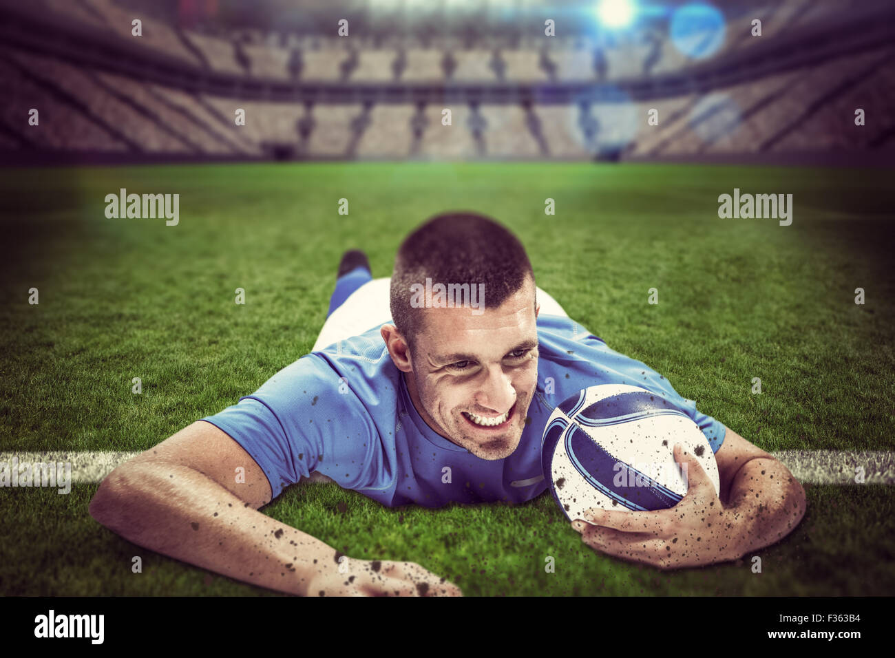 Composite image of confident rugby player lying in front with ball ...