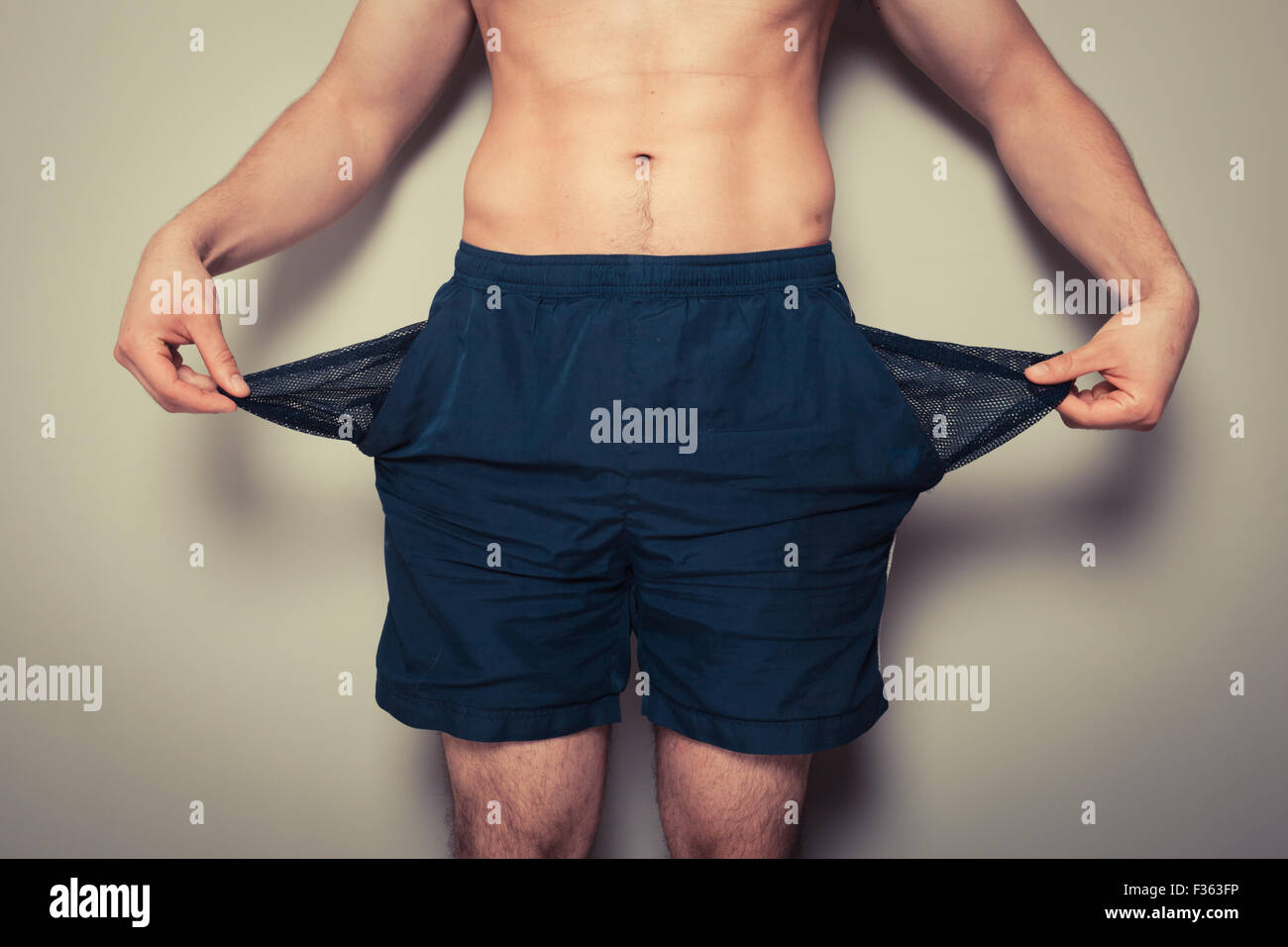 Athletic young man is showing his empty pockets Stock Photo - Alamy