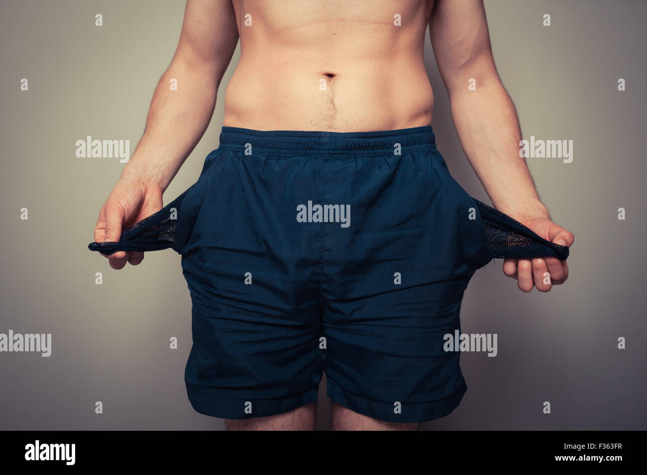Athletic young man is showing his empty pockets Stock Photo - Alamy