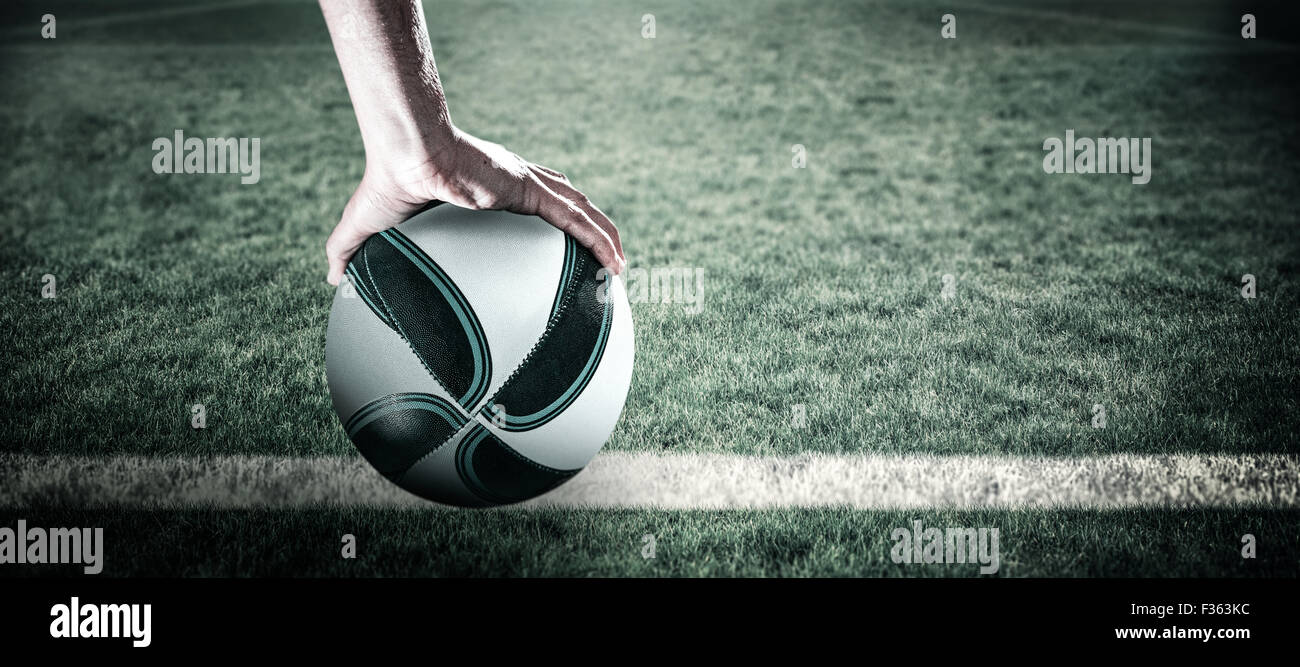 Composite image of rugby player with arm raised holding ball Stock ...