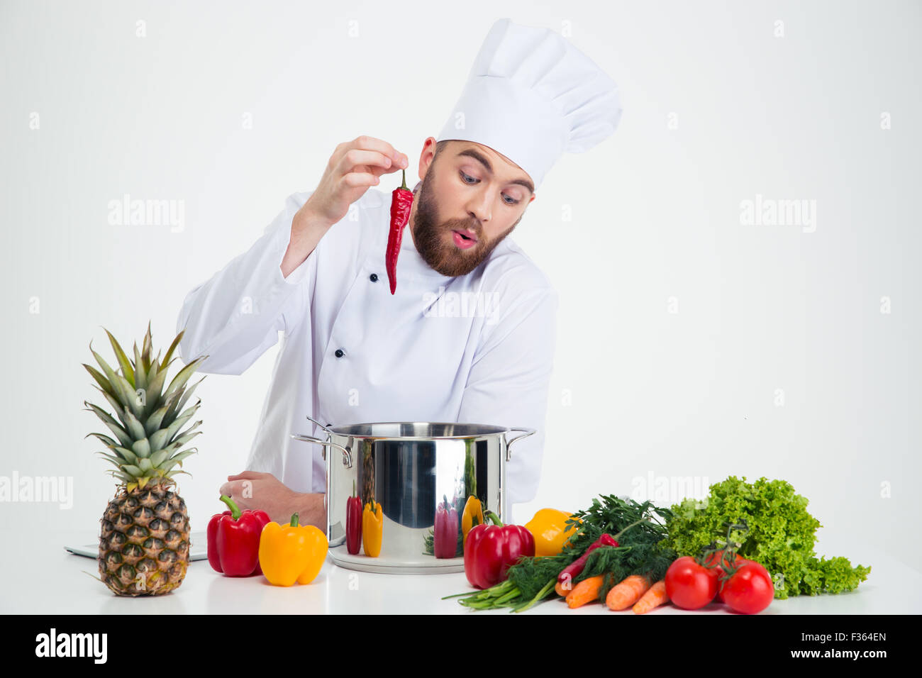 Portrait of a young chef cook preparing soup isolated on a white ...