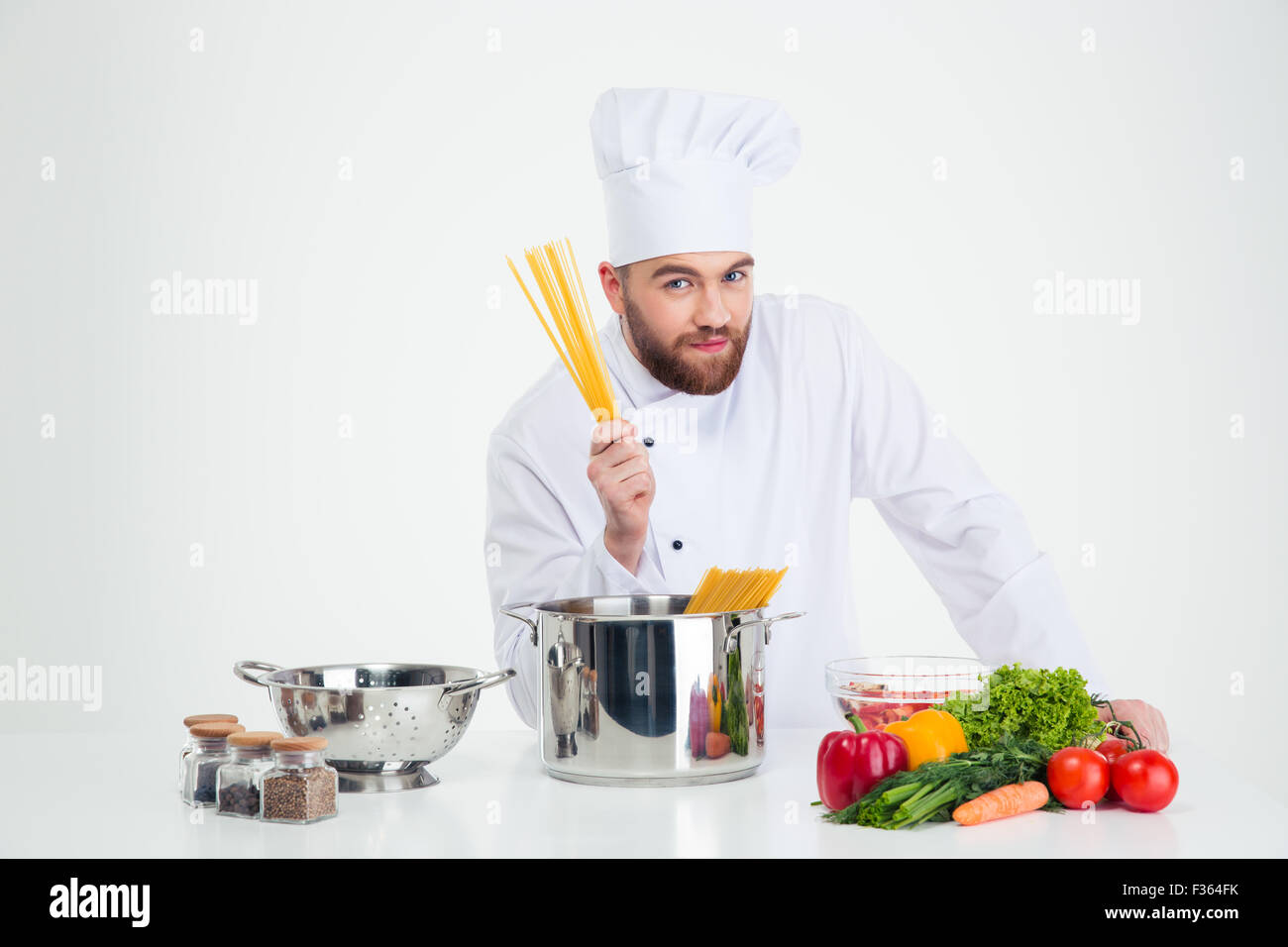 Portrait of a male chef cook preparing pasta isolated on a whtie ...