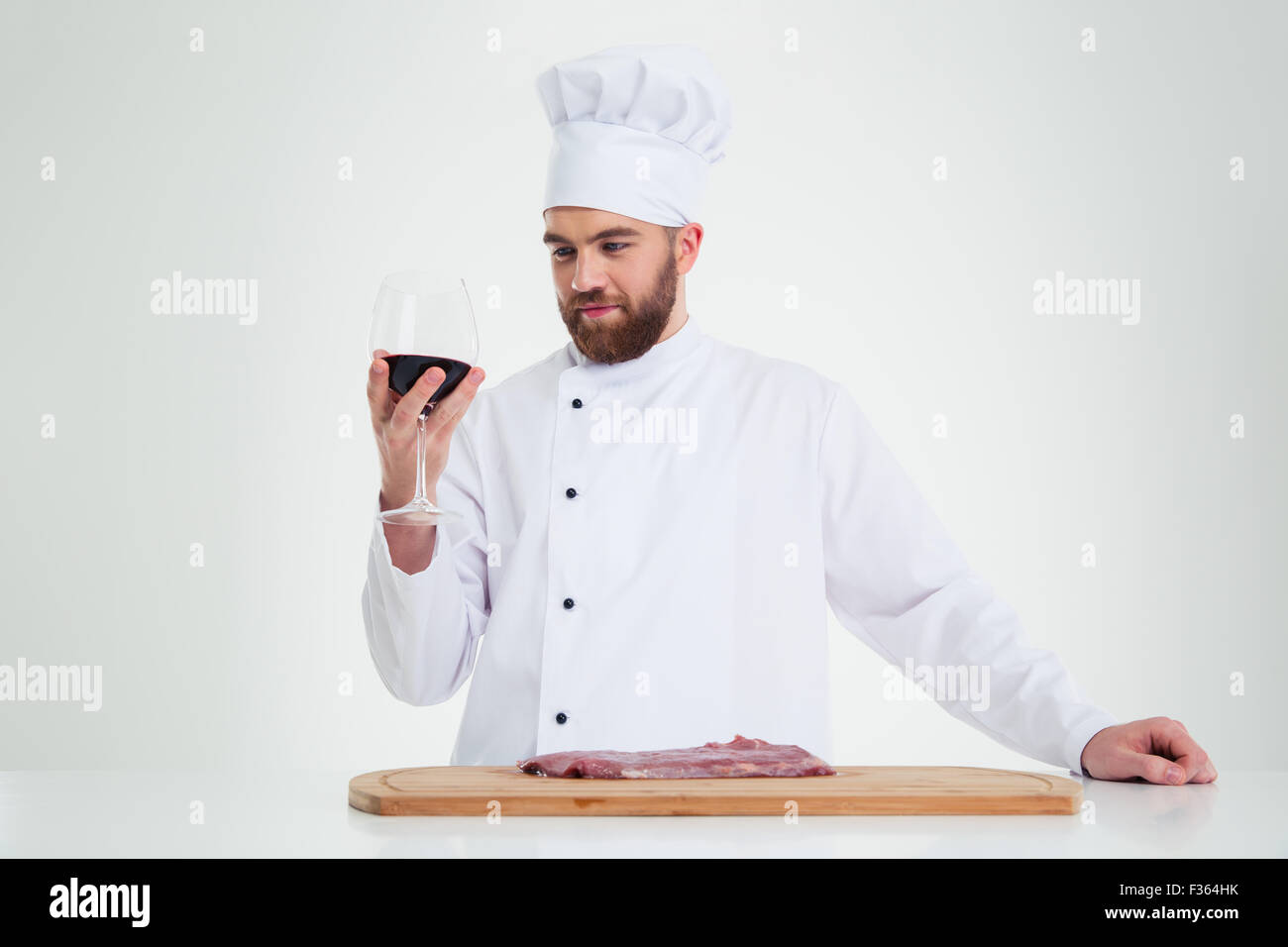 Portrait of a handsome male chef cook degusting wine isolated on a ...