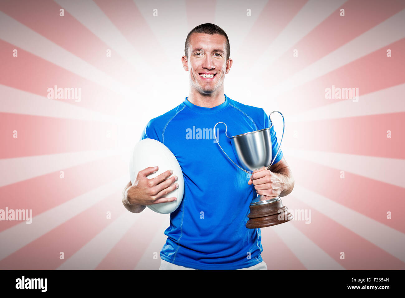 Composite image of portrait of smiling rugby player holding trophy and ...