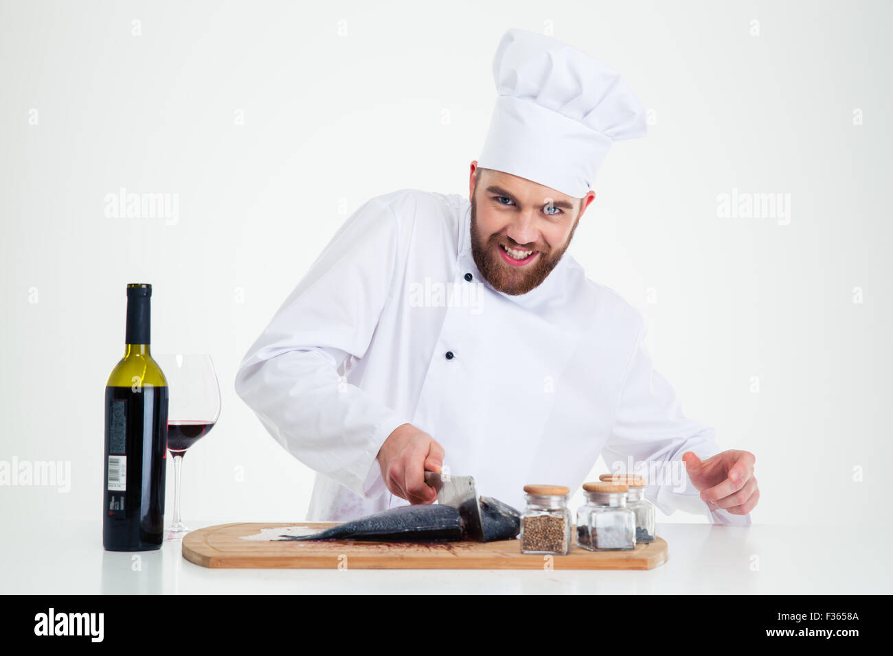 Portrait of a smiling male chef cook cutting fish isolated on a white ...