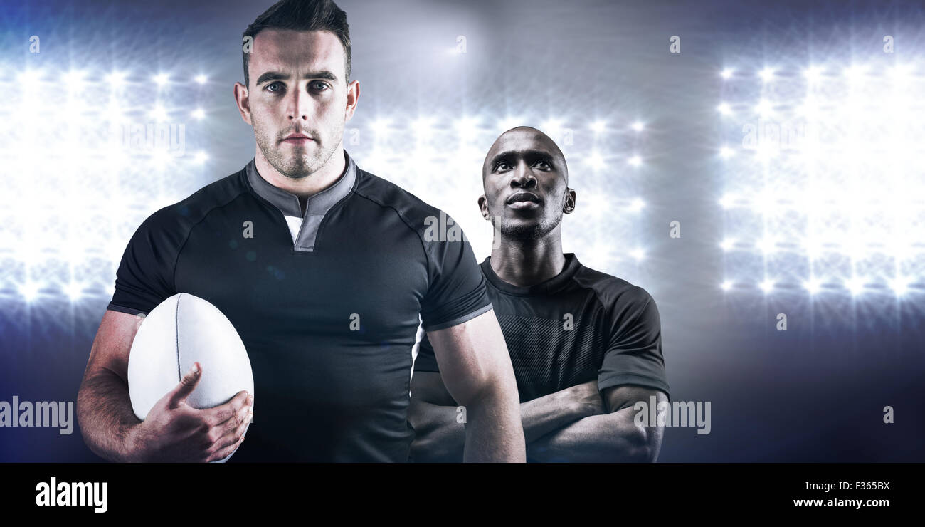 Composite image of tough rugby player holding ball Stock Photo - Alamy
