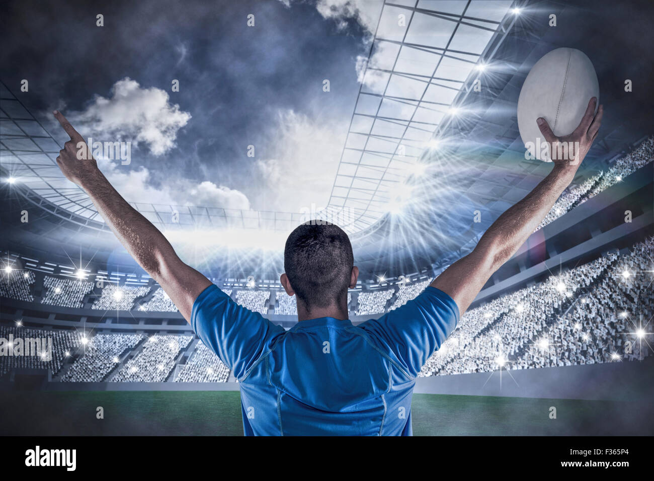 Composite image of rear view of rugby player holding ball with arms ...