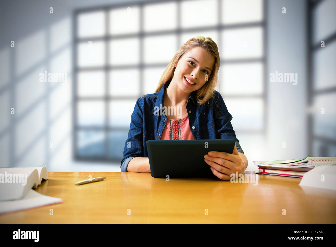 Composite image of student studying in the library with tablet Stock ...