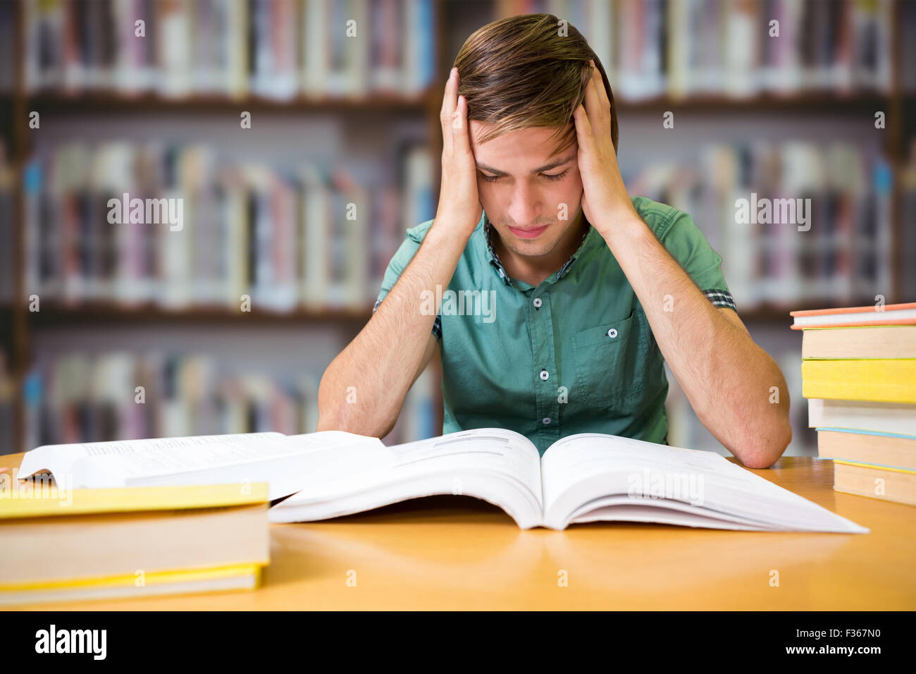 Composite image of student sitting in library reading Stock Photo - Alamy