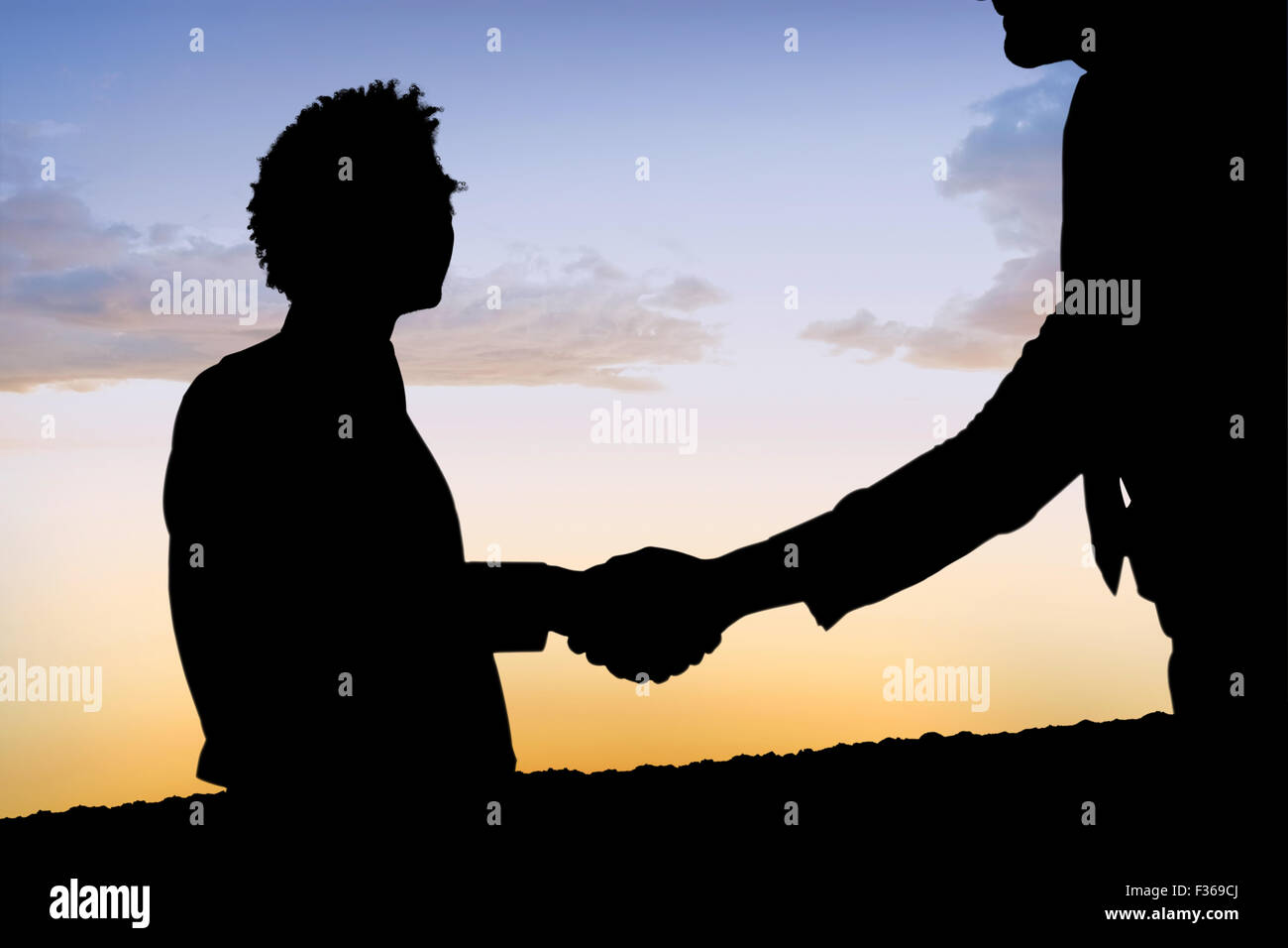 Composite image of silhouettes shaking hands Stock Photo - Alamy