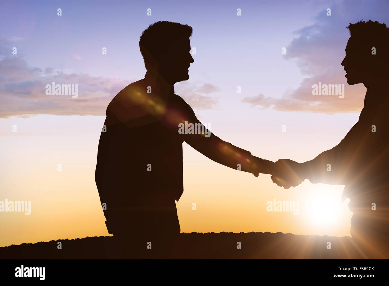 Composite image of silhouettes shaking hands Stock Photo - Alamy