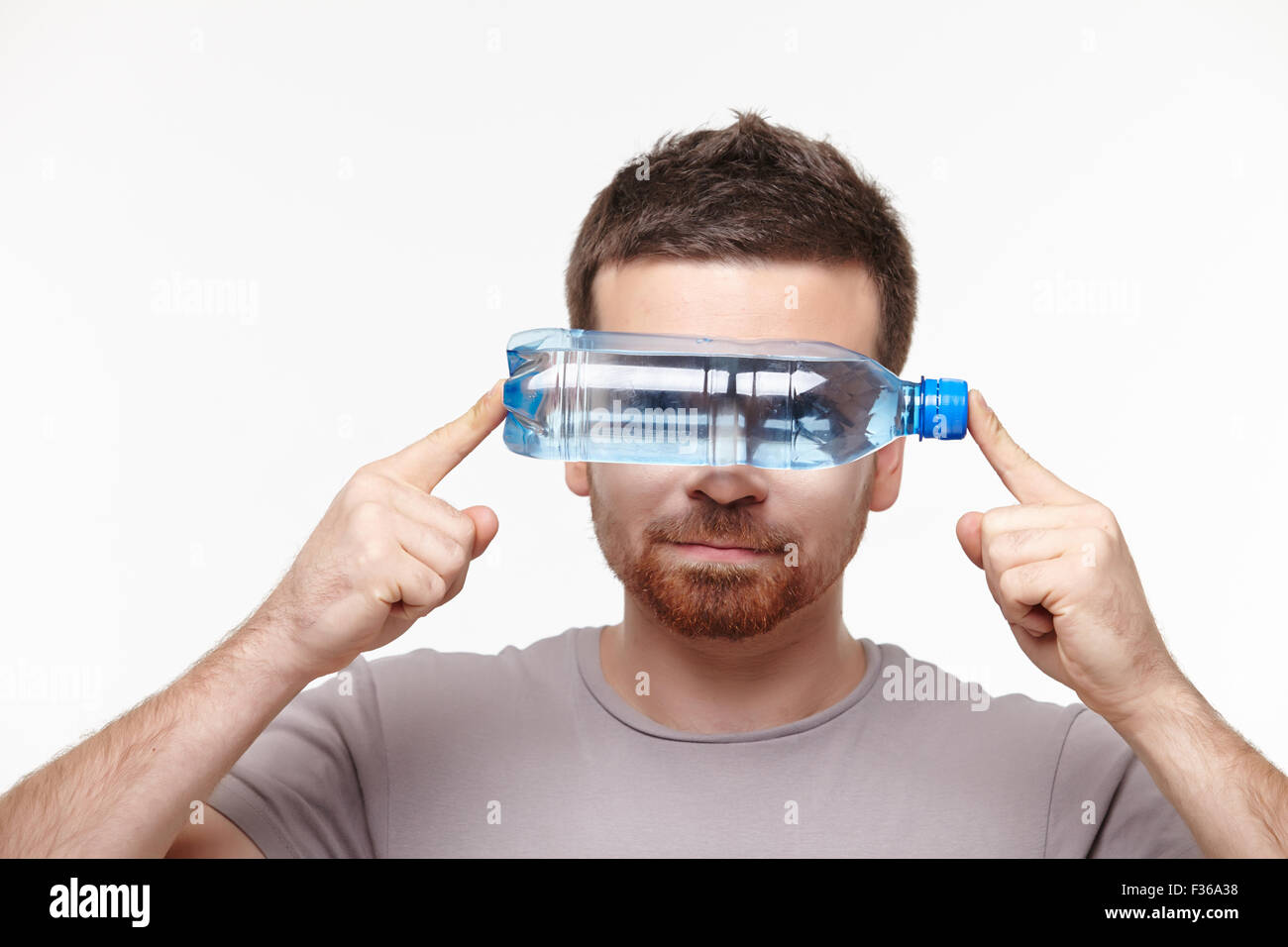 young smiling man looking through bottles of water Stock Photo - Alamy