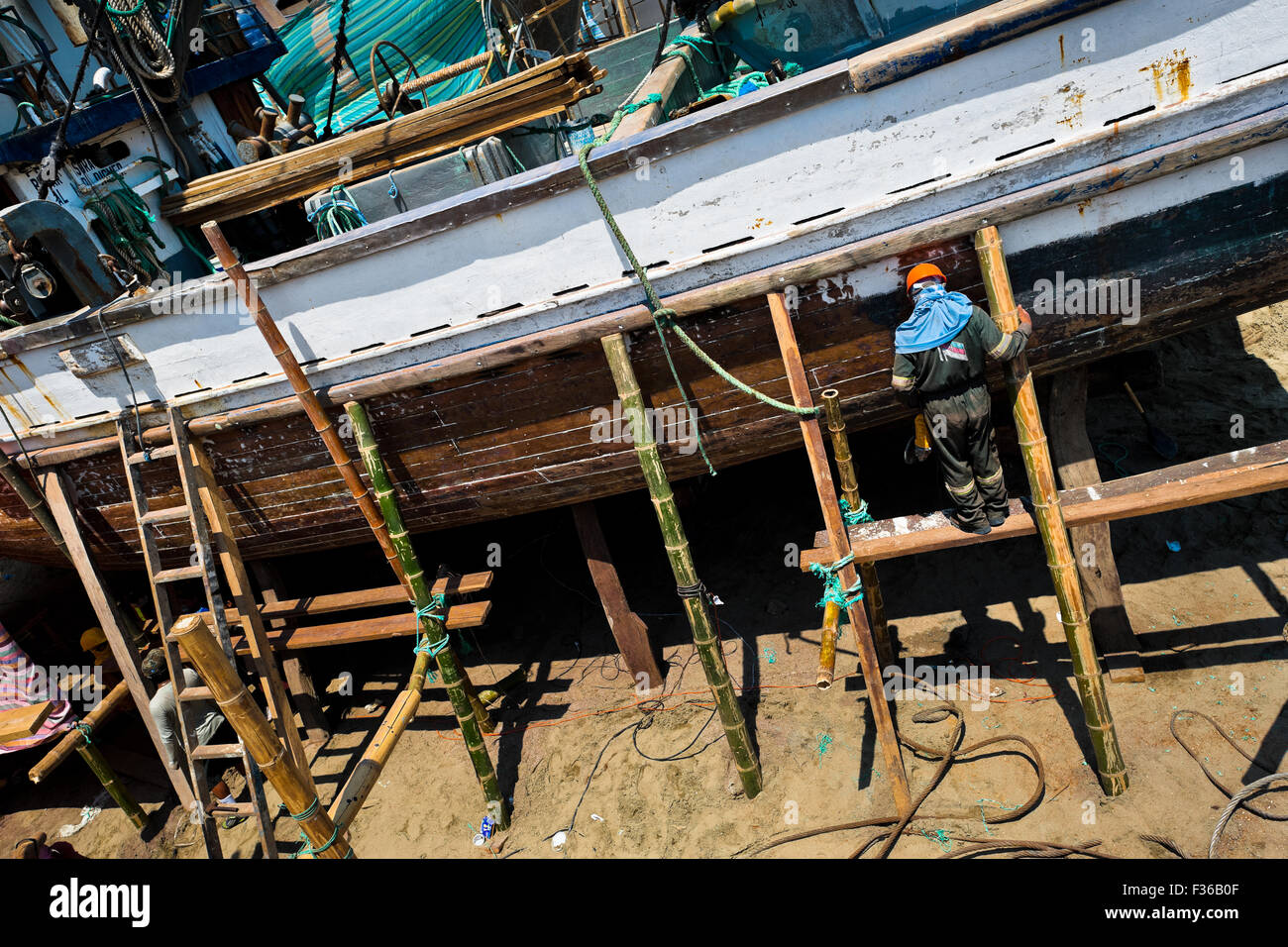 An Ecuadorian shipbuilding worker repairs the shell of a traditional ...