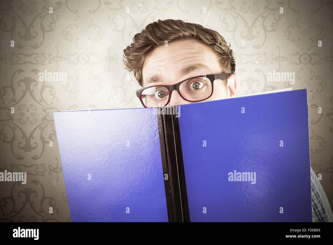 Composite image of geeky student reading a book Stock Photo - Alamy