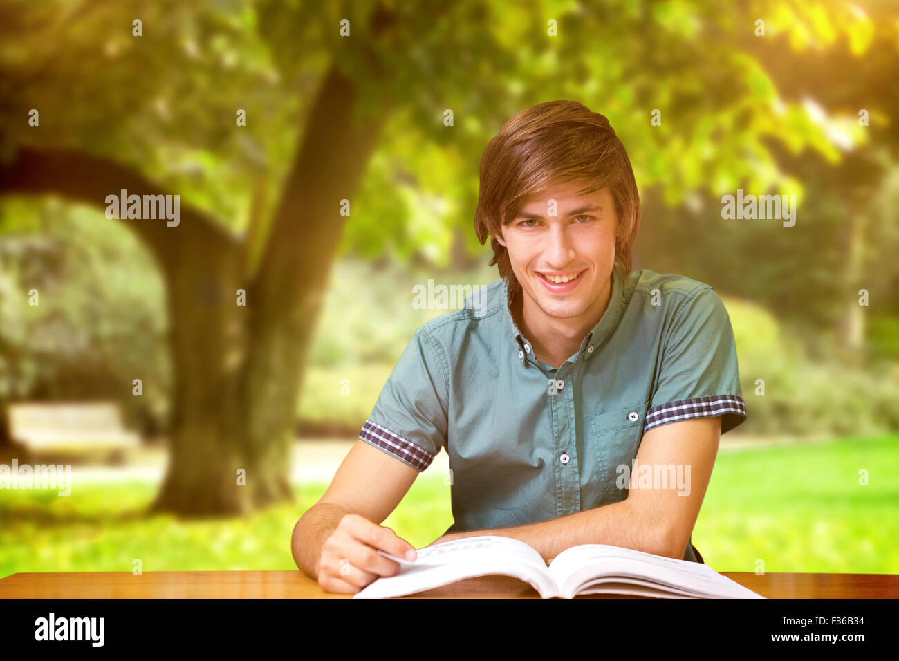 Composite image of student sitting in library reading Stock Photo - Alamy