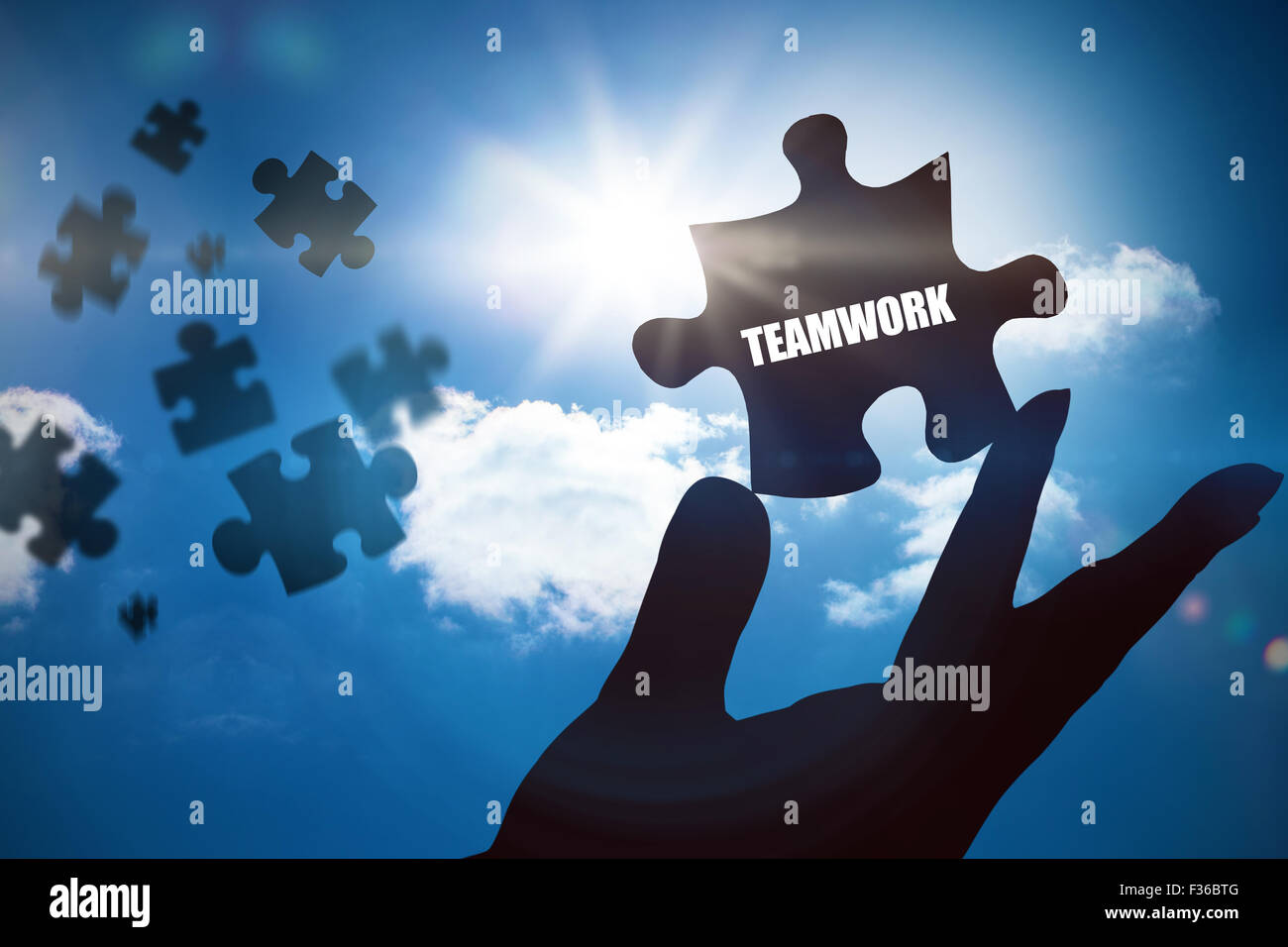 Teamwork against bright blue sky with clouds Stock Photo - Alamy