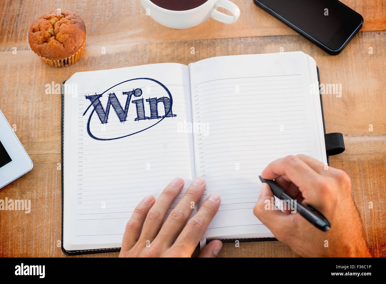 Win against man writing notes on diary Stock Photo - Alamy