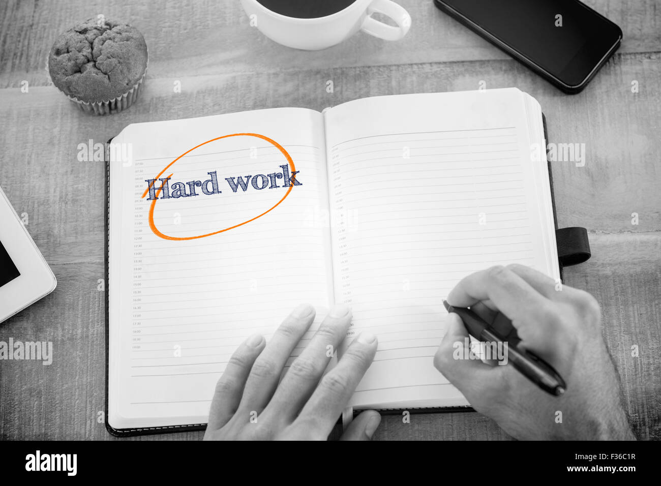 Hard work against man writing notes on diary Stock Photo - Alamy