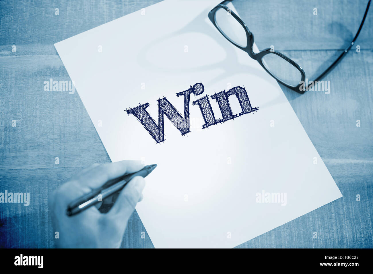 Win against left hand writing on white page on working desk Stock Photo ...