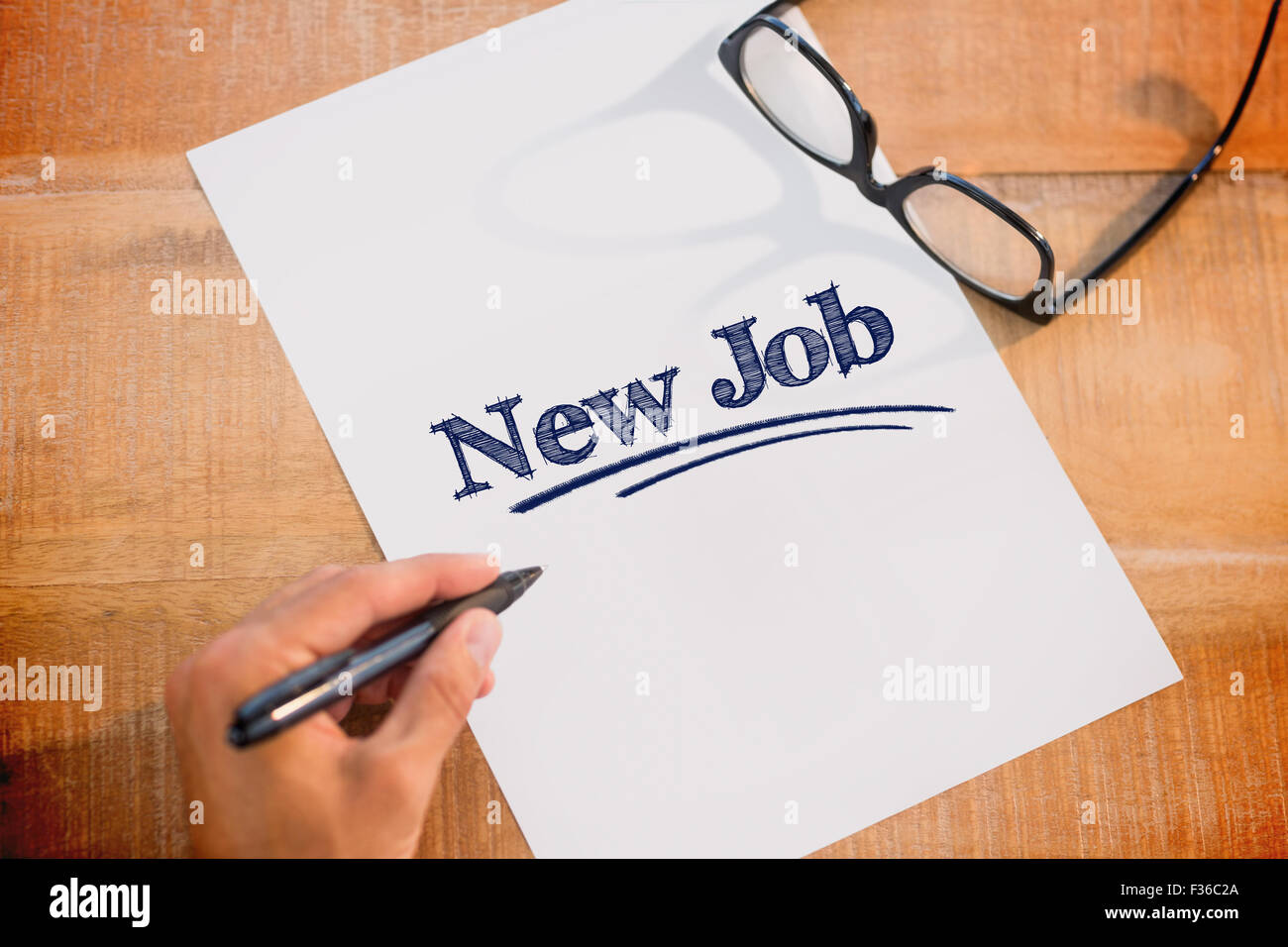 New job against left hand writing on white page on working desk Stock ...