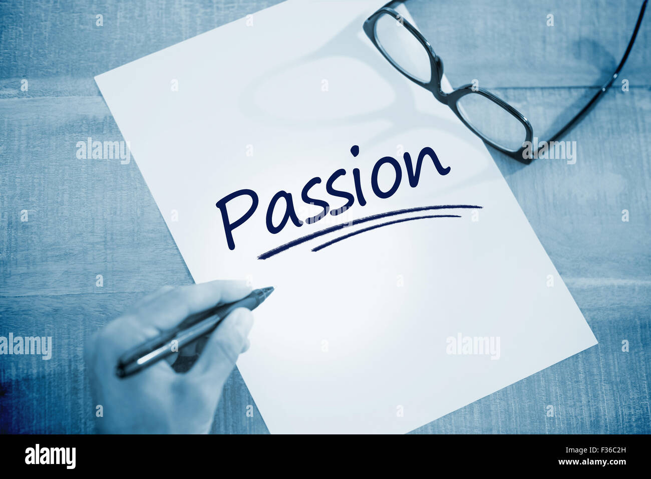 Passion against left hand writing on white page on working desk Stock ...