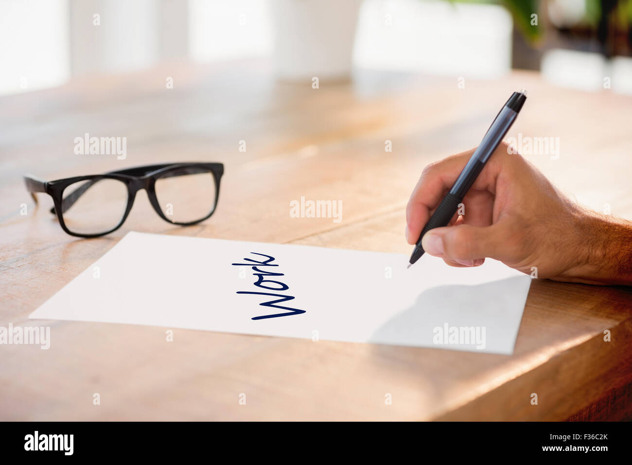 Work against side view of hand writing on white page on working desk ...