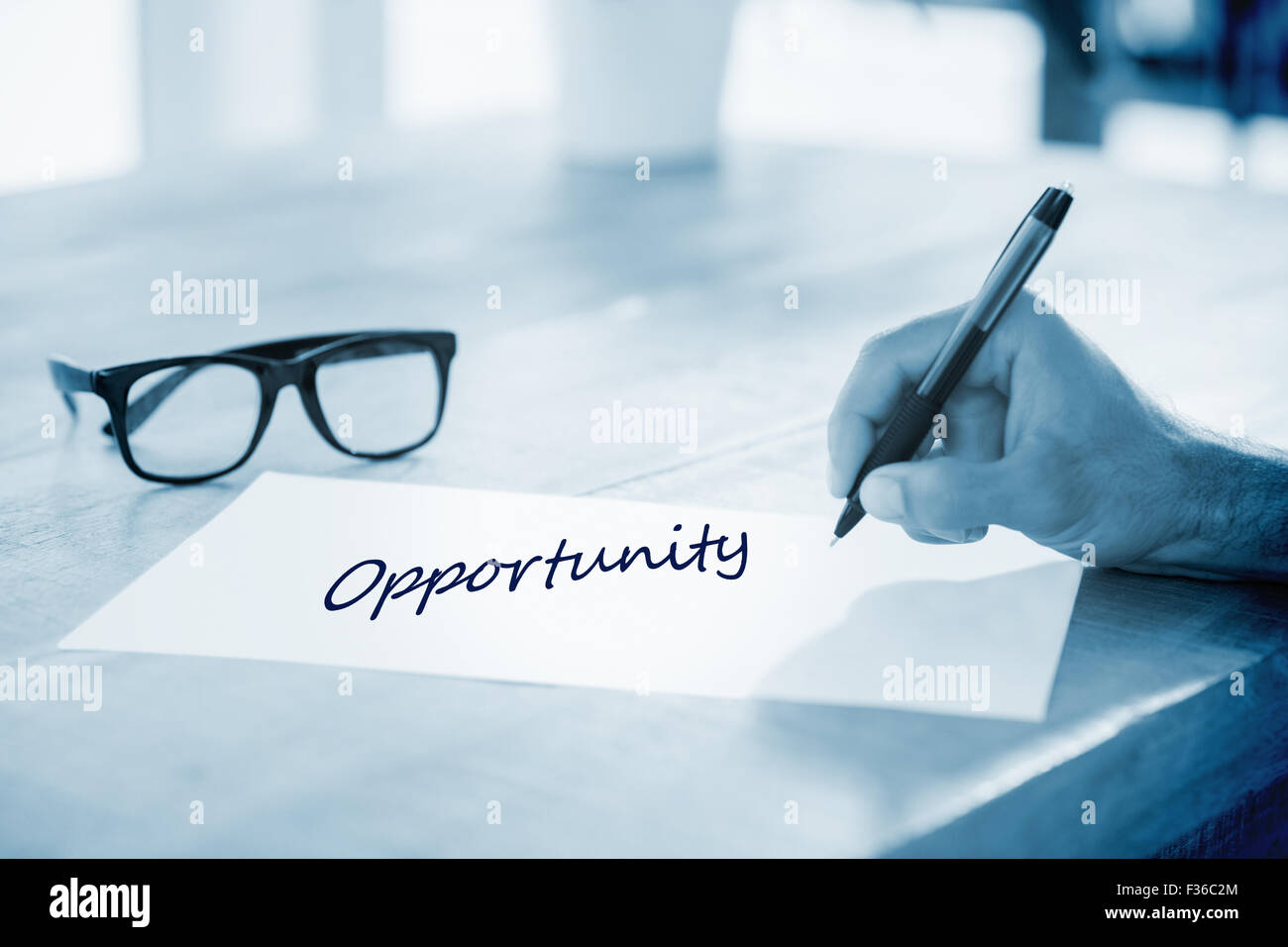 Opportunity against side view of hand writing on white page on working ...