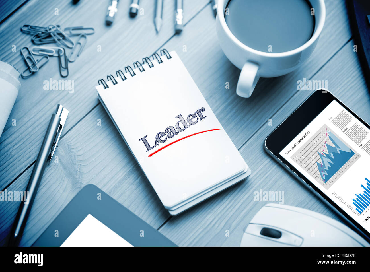 Leader against notepad on desk Stock Photo - Alamy